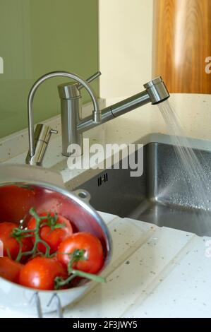 Water running from the modern styled faucet in the sink Stock Photo - Alamy