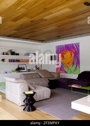 Interior of living room with grey sofa, table, pouf and stepladder near ...