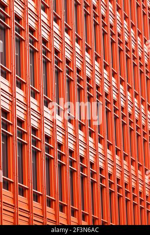 Red cladding panels on exterior of offices with shadow lines from slats ...