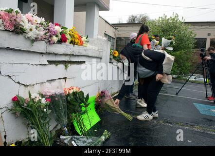 March 17, 2021, Atlanta, GA, USA: A woman arranges flower memorials at ...