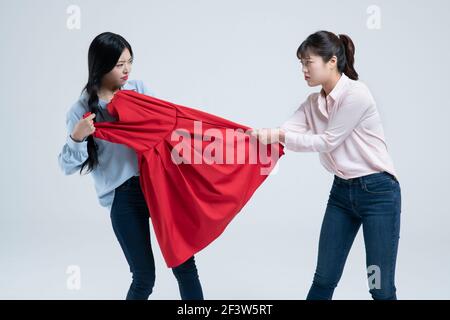 two young sisters fighting over some clothing Stock Photo - Alamy