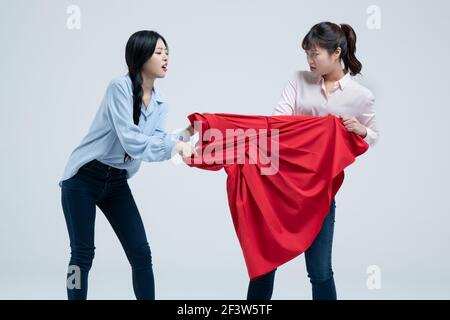 two young sisters fighting over some clothing Stock Photo - Alamy