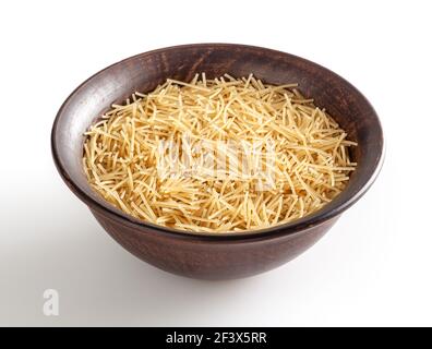 Uncooked vermicelli pasta in ceramic bowl on white wooden background ...