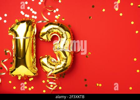 number thirteen, gold foil balloon number on a blue velvet background ...