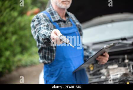 Car mechanic delivering car keys after car engine checking; multiple ...