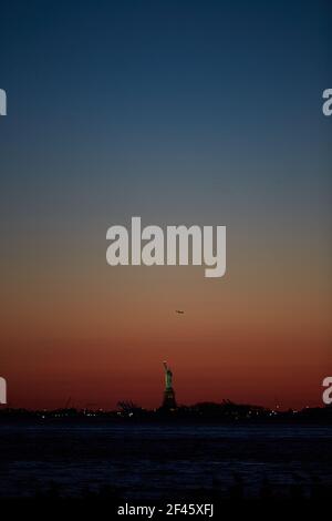 beautiful red sunset behind the statue of liberty Stock Photo - Alamy
