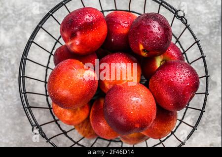 Fresh red nectarines in a steel basket. Gray background. Top view Stock ...