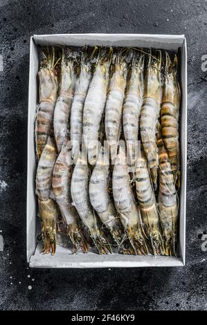 Package of frozen tiger prawns, shrimps. Black background. Top view ...