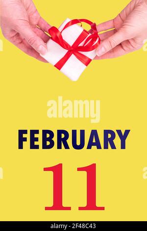 11th day of February. A hand holding a red pen and pointing on the ...