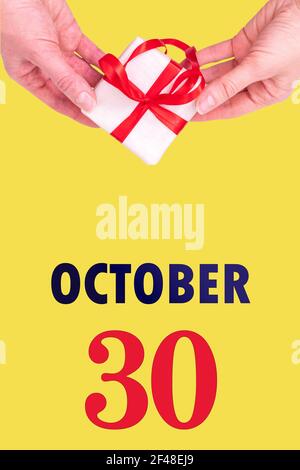 30th day of October. A hand holding a red pen and pointing on the ...