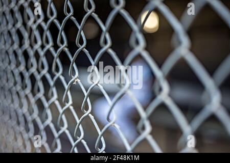 Wire metal fence with baseball field diamond in background. Taken in ...