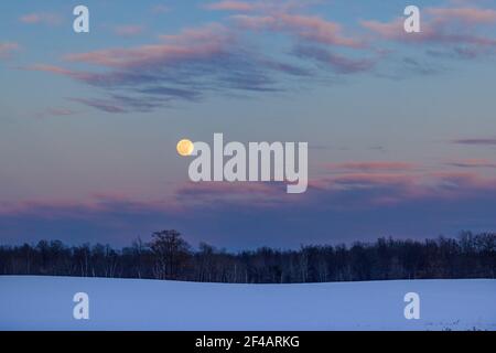 A full moon rising over a wintery landscape in northern Wisconsin Stock ...