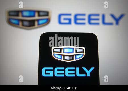 In this photo illustration, Geely logo seen on a smartphone and a pc ...
