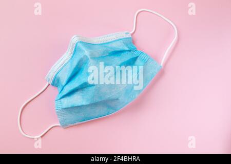 Used pink medical mask on a pink background. Disposable 3-ply medical ...