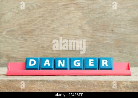 Tile alphabet letter with word harmful in red color rack on wood ...