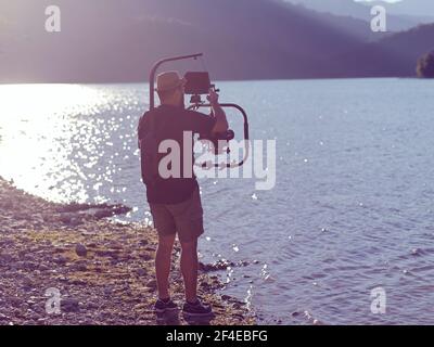 videographer taking action shot of triathlon athlete while riding bike ...