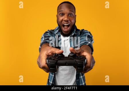 Excited Black Guy Playing Videogame Holding Game Controller In Studio ...
