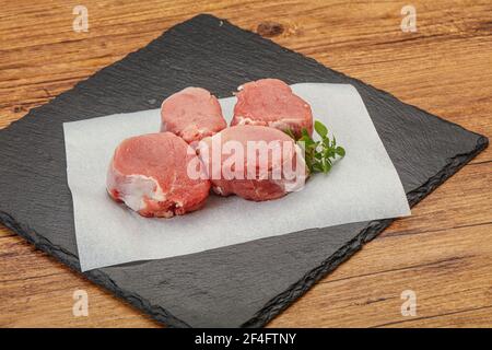 Raw pork medallion served rosemary for cooking Stock Photo - Alamy