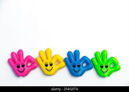 Four colour small plastic hands with smile on face making the OK sign ...