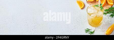 glass of whiskey on stone with rosemary flowers, lemon wedges and ...