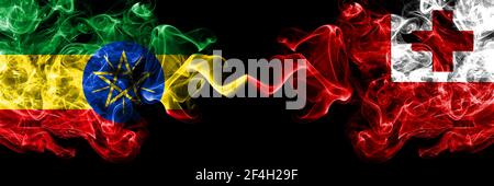 Ethiopia and Tonga flag waving in the wind against white cloudy blue ...