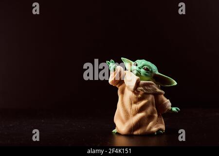 March, 2021: Display of Baby Yoda, an action figures, stands on a gray ...