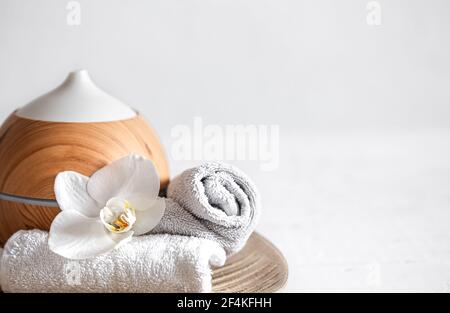Close up of air humidifier, towel and orchid flower. Aromatherapy and ...