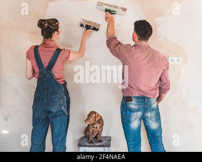 Adorable married couple doing home makeover with yellow color Stock ...