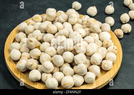 roasted and salted black chickpeas scattered from a paper cone, also ...