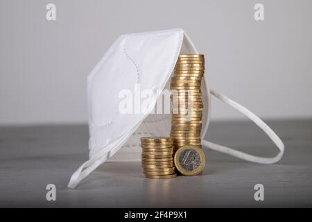 ffp2 mask with many one EURO coins as symbol for cost for corona ...