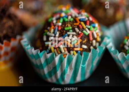 Closeup shot of rainbow sprinkle munchkins on paper muffin cups Stock ...