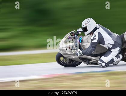 Motorcycle practice leaning into a fast corner on track Stock Photo - Alamy
