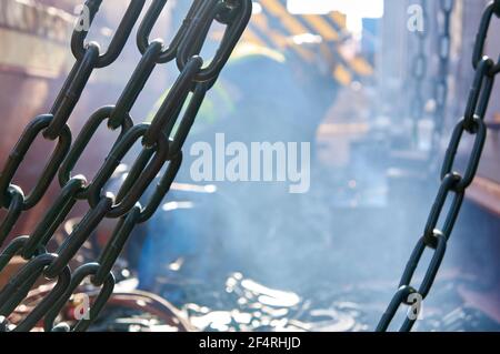 Welder doing welding on deck of ship lashing cargo for sea shipping on ...