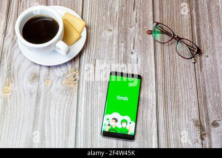 A mobile phone or cell phone laid on a wooden table or desk with the ...