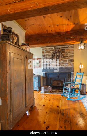 Fieldstone fireplace and blue distressed antique wooden rocking chair ...