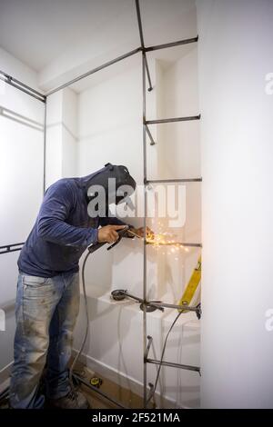 Worker welding a dressing room in a home renovation Stock Photo - Alamy