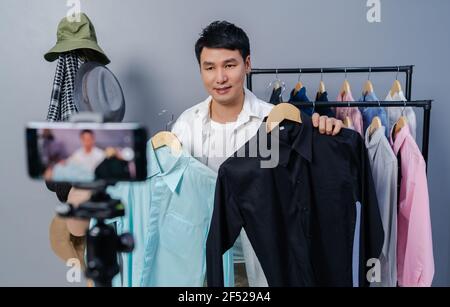 young man selling clothes and accessories online by laptop computer ...