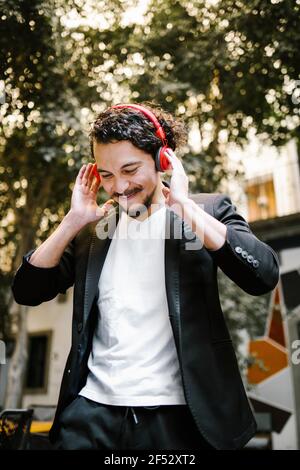 Young handsome hispanic man playing video game sitting by the sofa ...