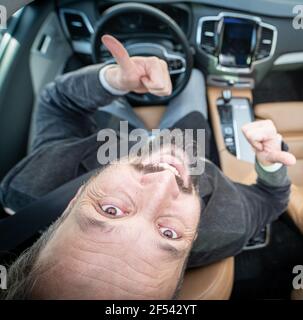 Funny wide angle of a male driver in luxury car Stock Photo - Alamy