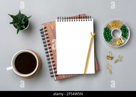 open notepad, cup of coffee, succulents, golden pen on gray background ...