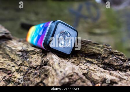 Colorful bicycle lamp on the background of a wooden log. Picture taken ...