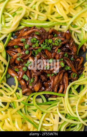 Zucchini spaghetti with shimeji on black stone plate Stock Photo - Alamy