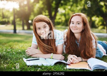 Two beautiful sisters do their homework during quarantine. Children use ...