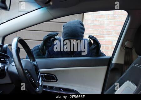 Thief looking to break into car window Stock Photo - Alamy