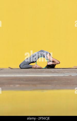 Young woman bending backwards and doing yoga in exercise room Stock ...