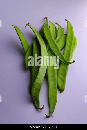 Flat pods of raw helda romano string beans and green leaves float in ...