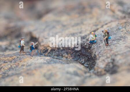 Fun concept of miniature hiker figure adventure in the rocks, outdoor ...