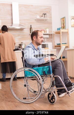 disabled woman preparing vegetables while sitting in wheelchair near ...