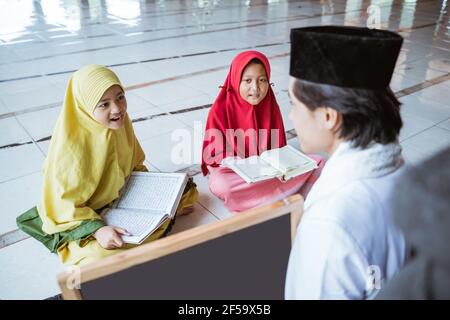 two kids learning to read quran with muslim teacher or ustad Stock ...