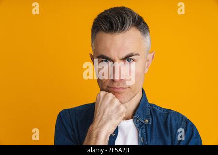 Displeased handsome man posing and looking at camera isolated over ...